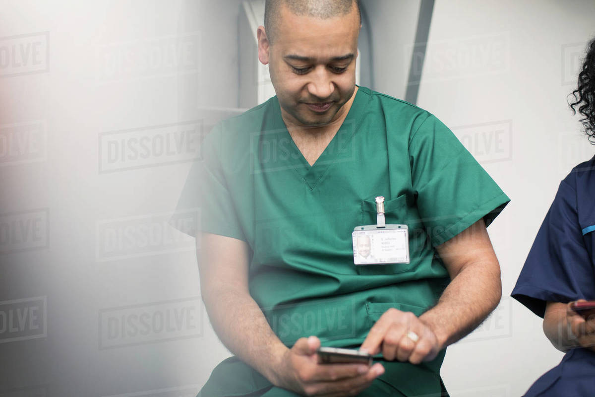Male surgeon using smart phone - Royalty-free Stock Photo | Dissolve