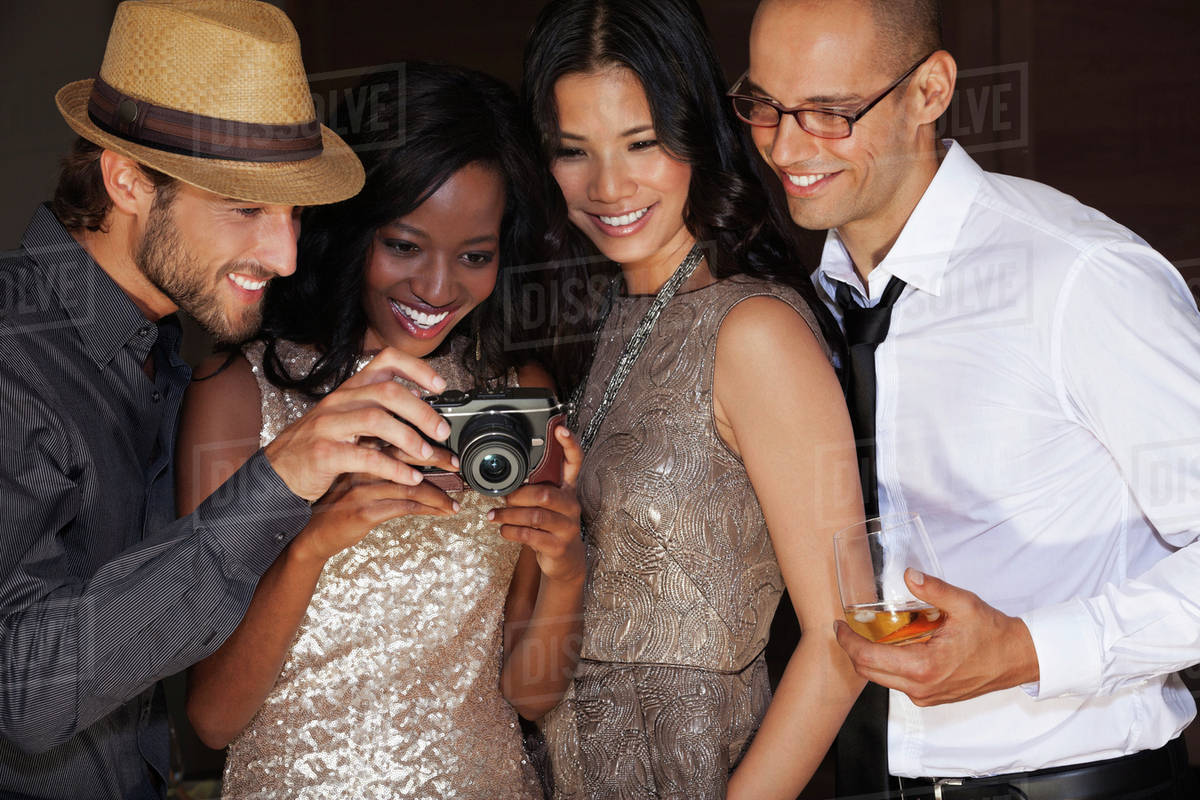 Friends using camera at party - Stock Photo - Dissolve