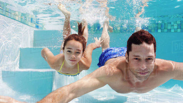 Father and daughter swimming in pool - Royalty-free Stock Photo | Dissolve