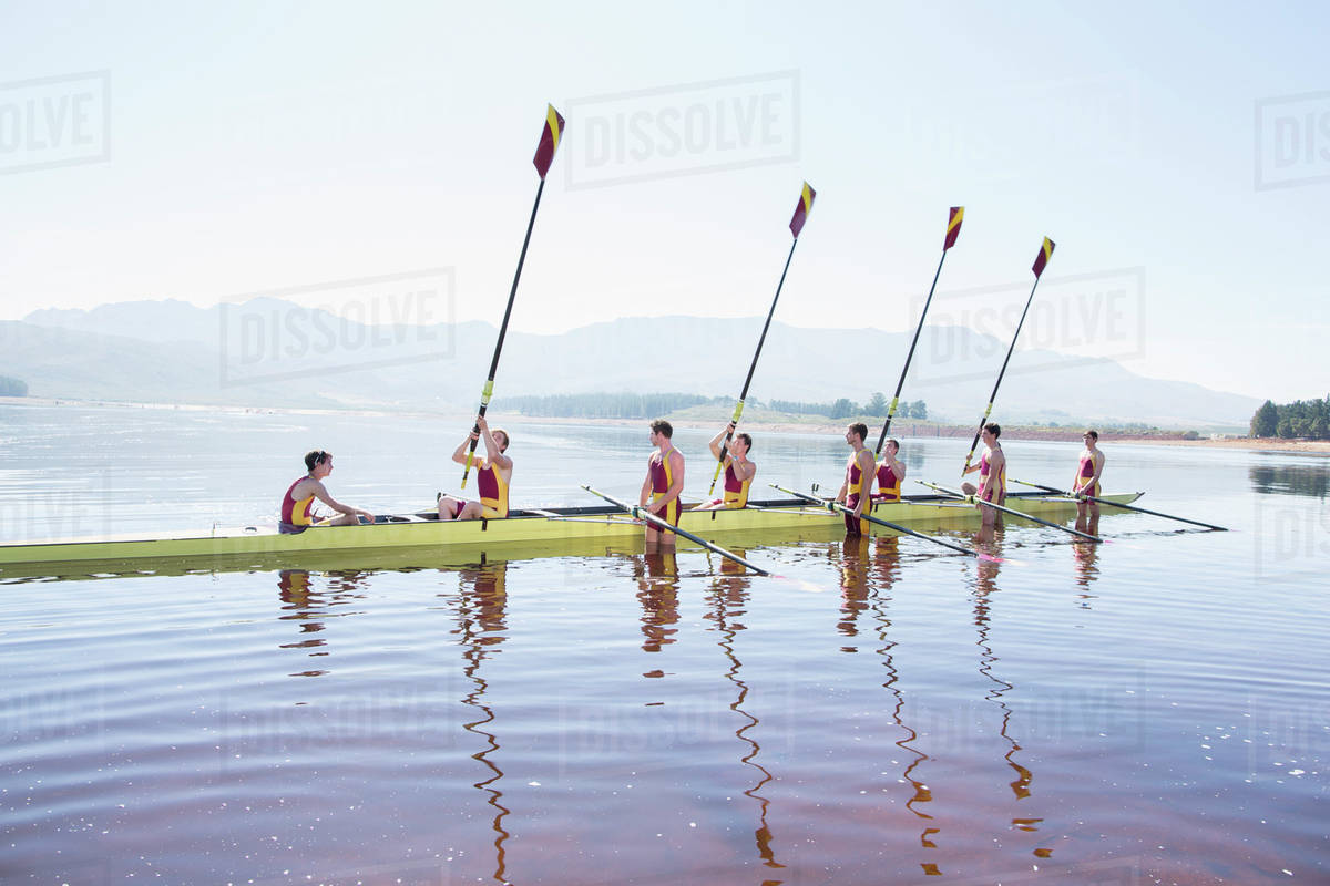 Rowing team with oars raised on lake - Royalty-free Stock Photo | Dissolve