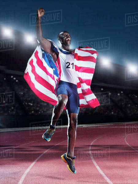 Runner holding American flag and celebrating on track - Royalty-free ...