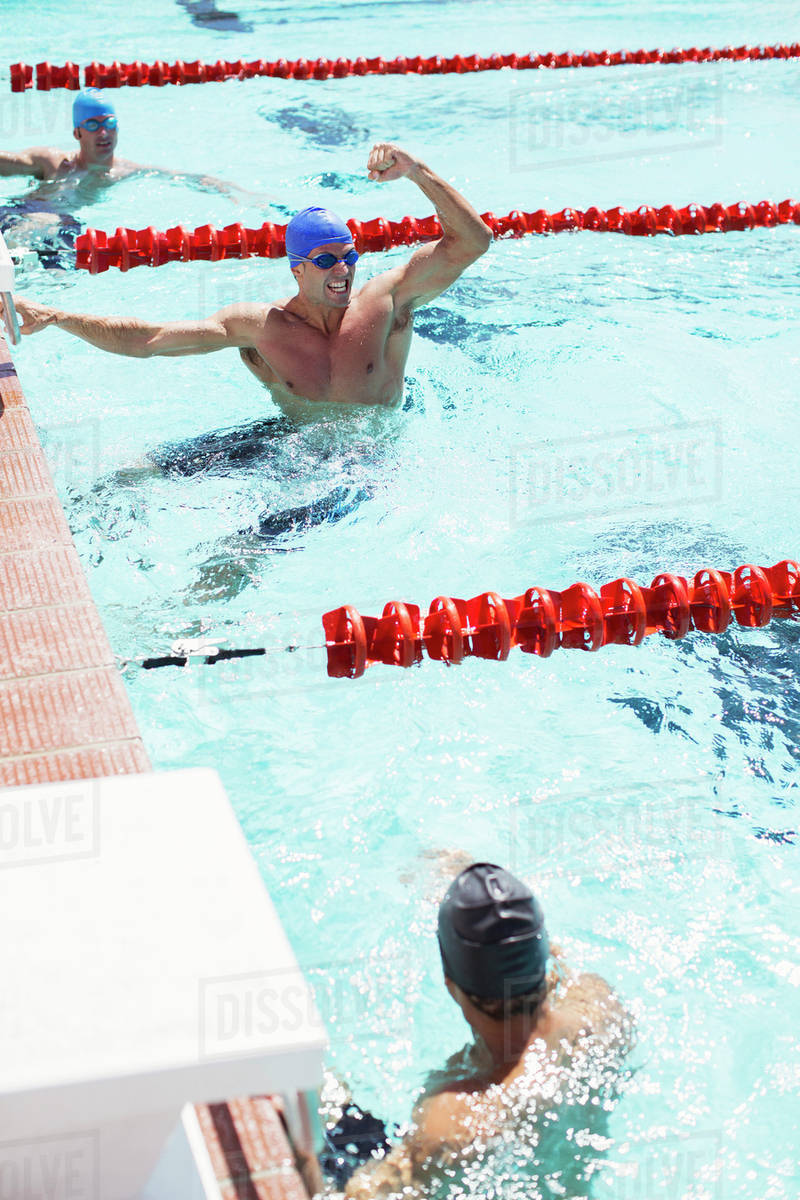 Swimmer celebrating in pool - Stock Photo - Dissolve
