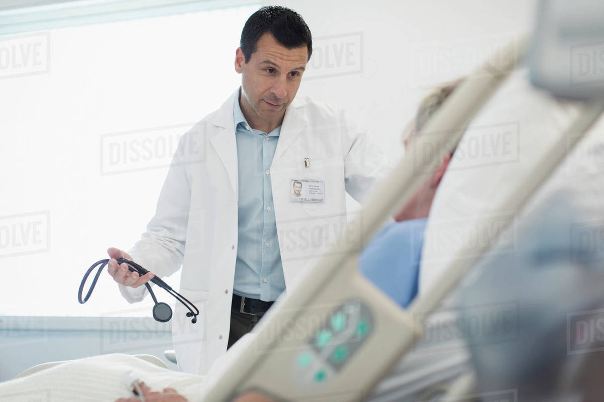 Doctor making rounds, talking with patient in hospital room - Royalty ...