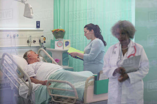 Doctors making rounds, talking with patient in hospital room - Royalty ...
