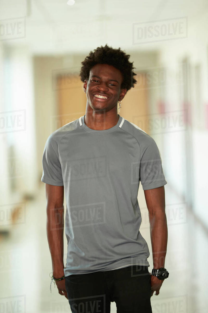 Portrait confident happy high school boy in corridor - Royalty-free ...