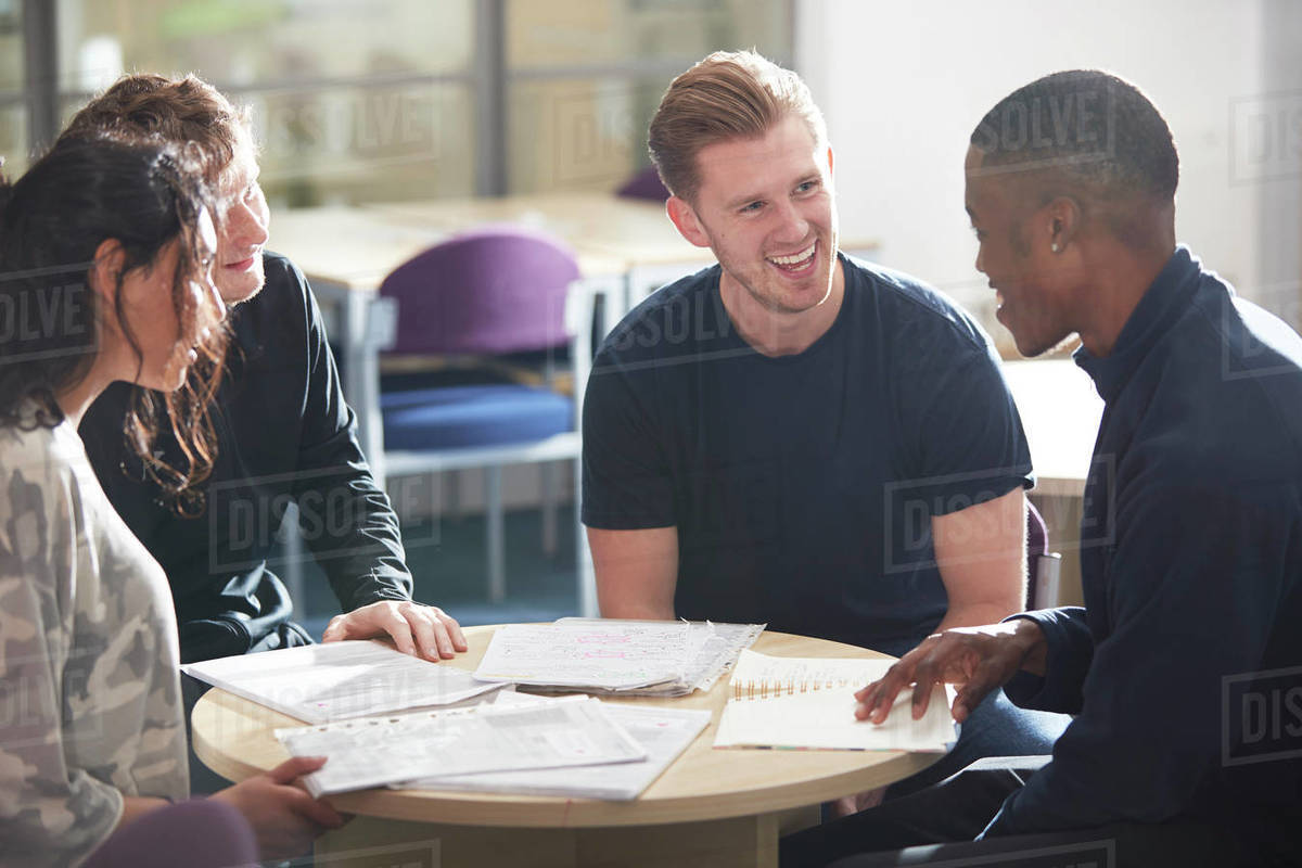 Happy young college students talking and studying in library - Stock ...