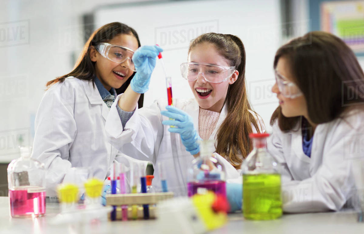 Curious girl students conducting scientific experiment in laboratory ...