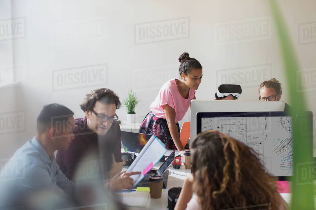 Computer programmers and designers working in open plan office ...