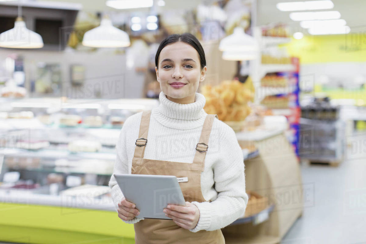 Portrait confident female grocer with digital tablet working in ...