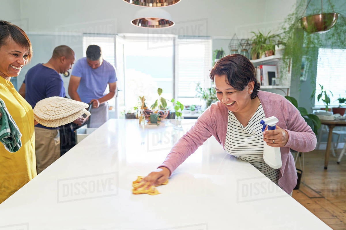 Happy women friends cleaning kitchen island - Royalty-free Stock Photo ...