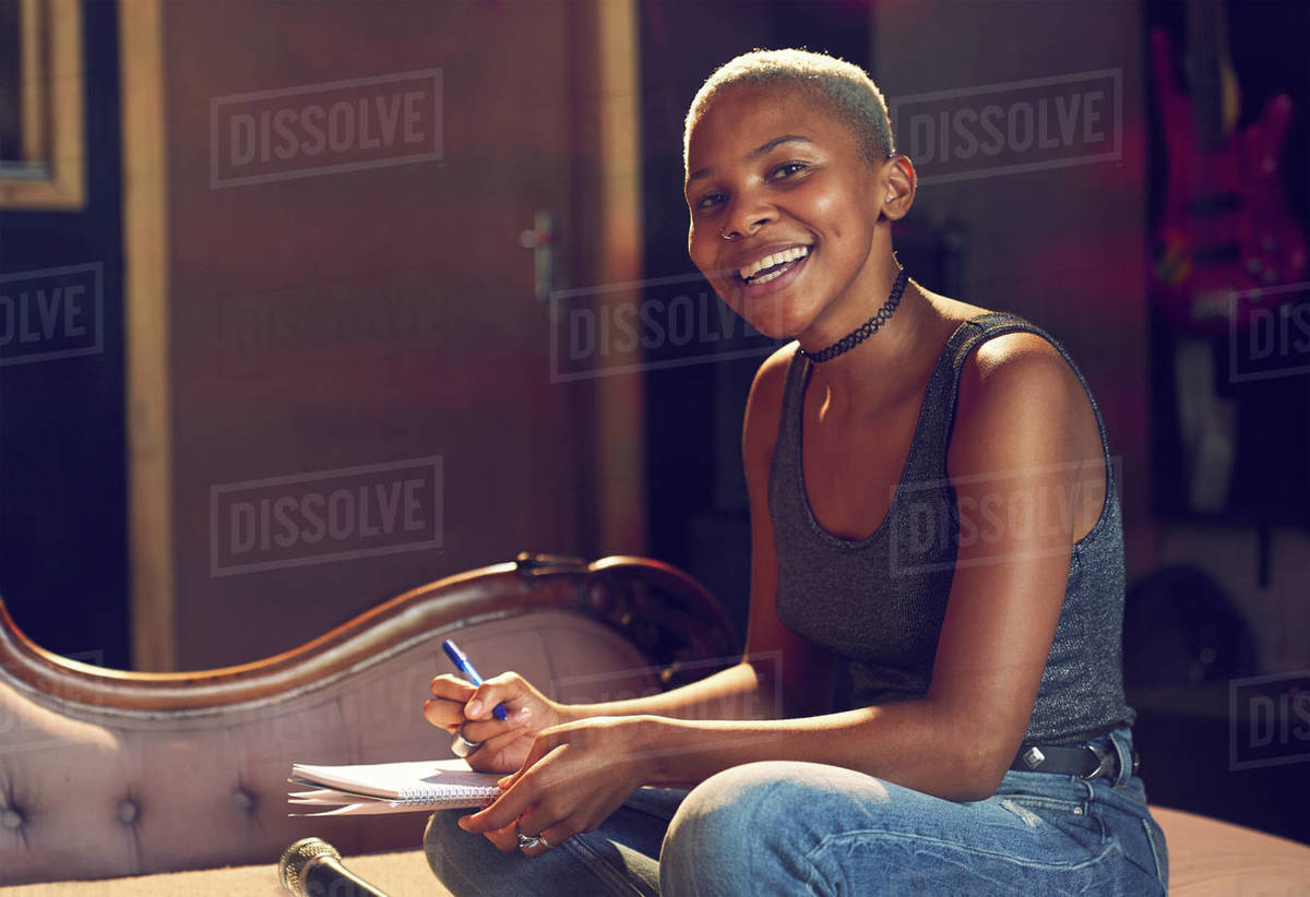 Portrait confident female musician song writing - Stock Photo - Dissolve