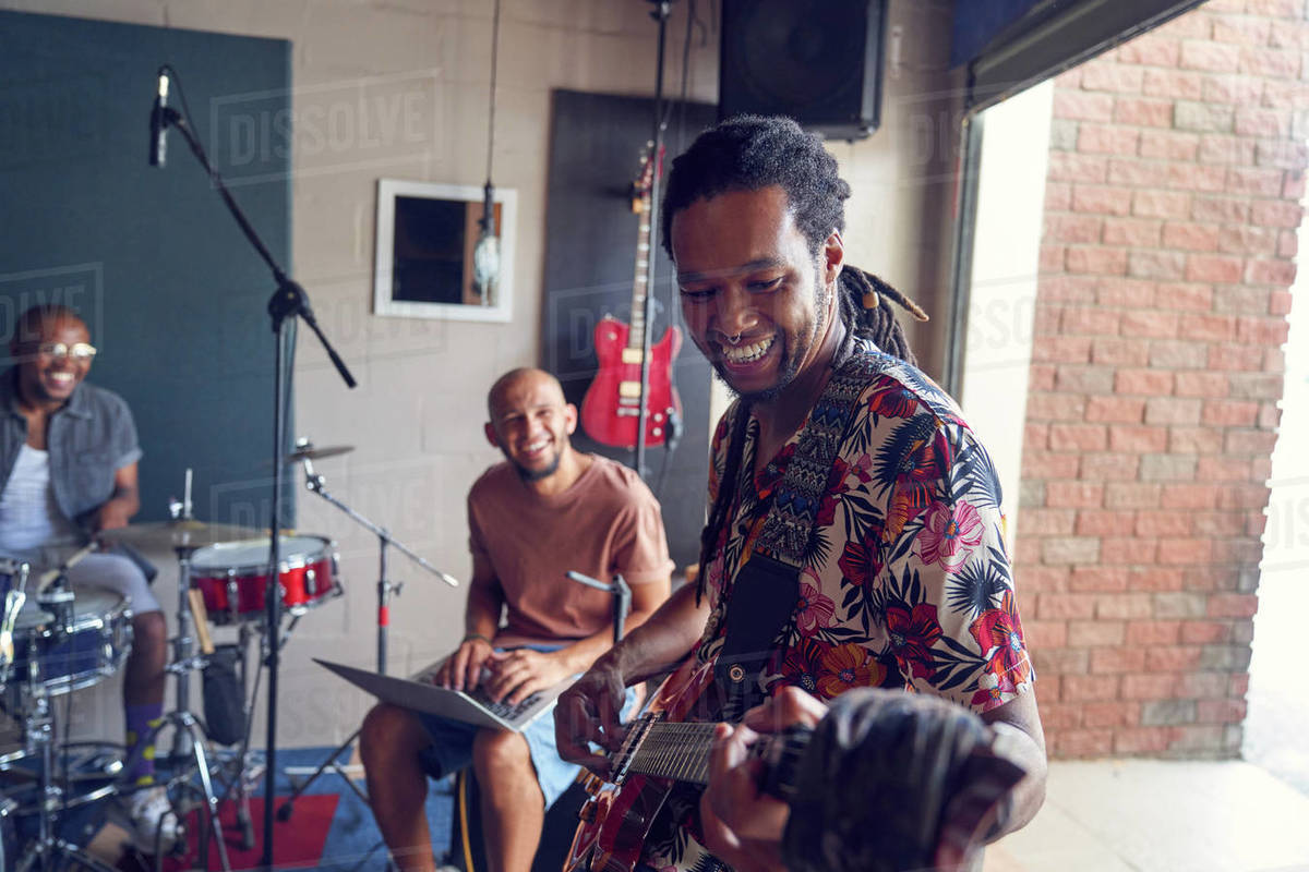 Smiling male musicians practicing in garage recording studio - Royalty ...