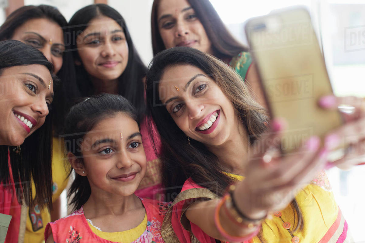 Happy Indian women and girls in saris taking selfie - Royalty-free ...