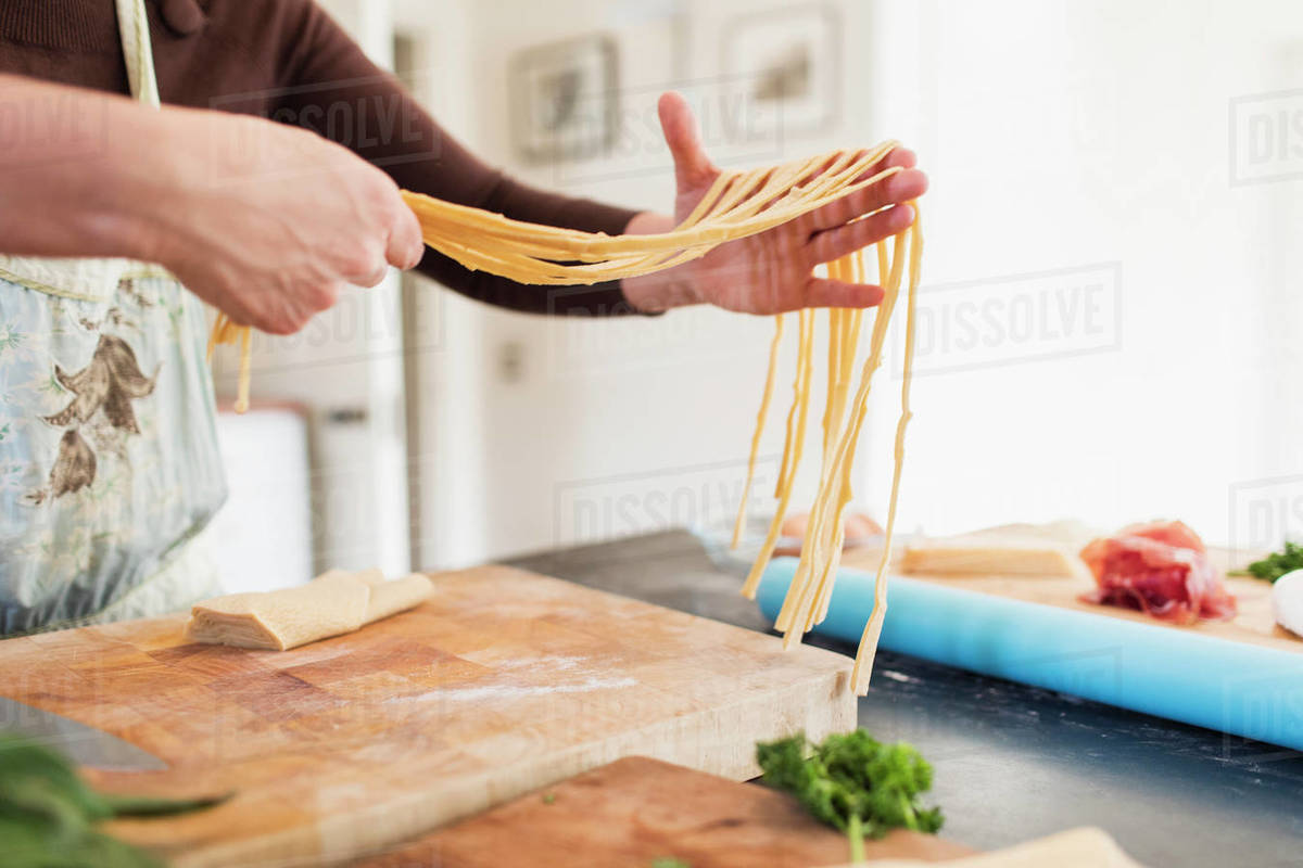 Close up woman making fresh homemade pasta in kitchen - Royalty-free ...