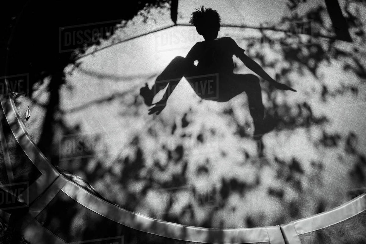 Shadow of boy jumping on sunny trampoline - Royalty-free Stock Photo ...