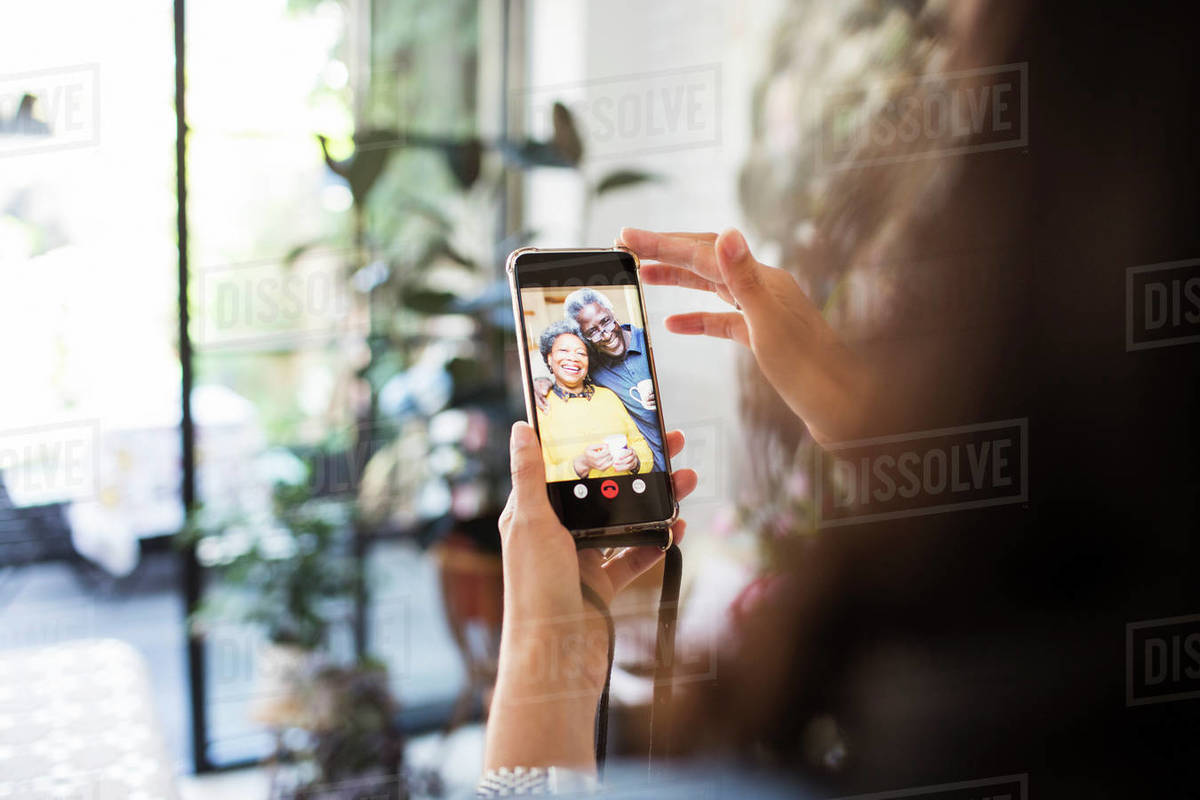 Woman video chatting with couple on smart phone screen - Stock Photo ...
