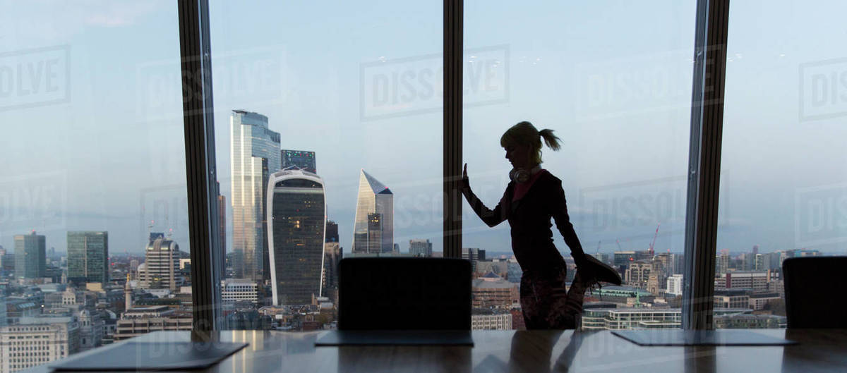 Businesswoman stretching at highrise office window, London, UK - Stock ...