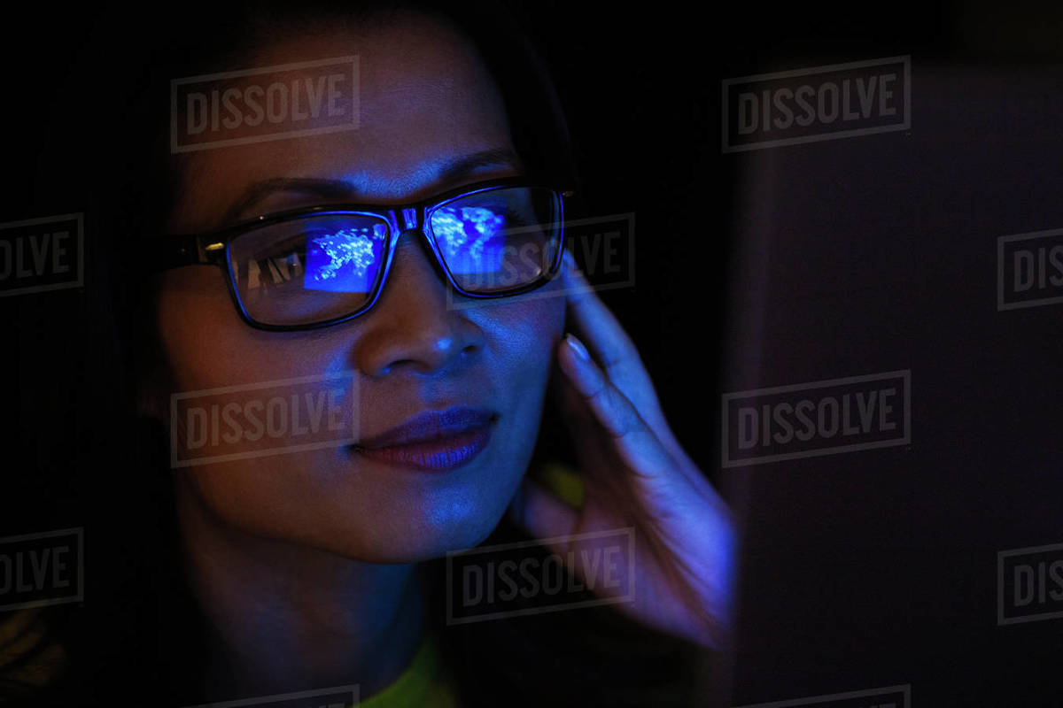 Close up laptop reflection in eyeglasses of businesswoman working late ...