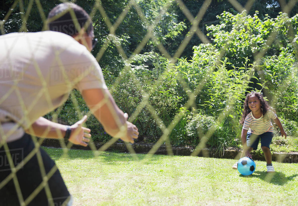 Father and daughter playing soccer in sunny summer backyard - Royalty ...