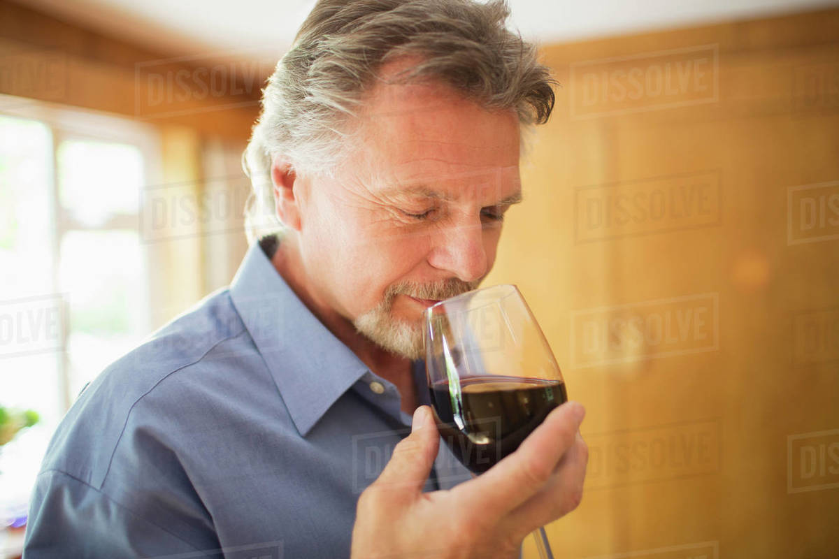 Close up serene man smelling and tasting red wine - Royalty-free Stock ...