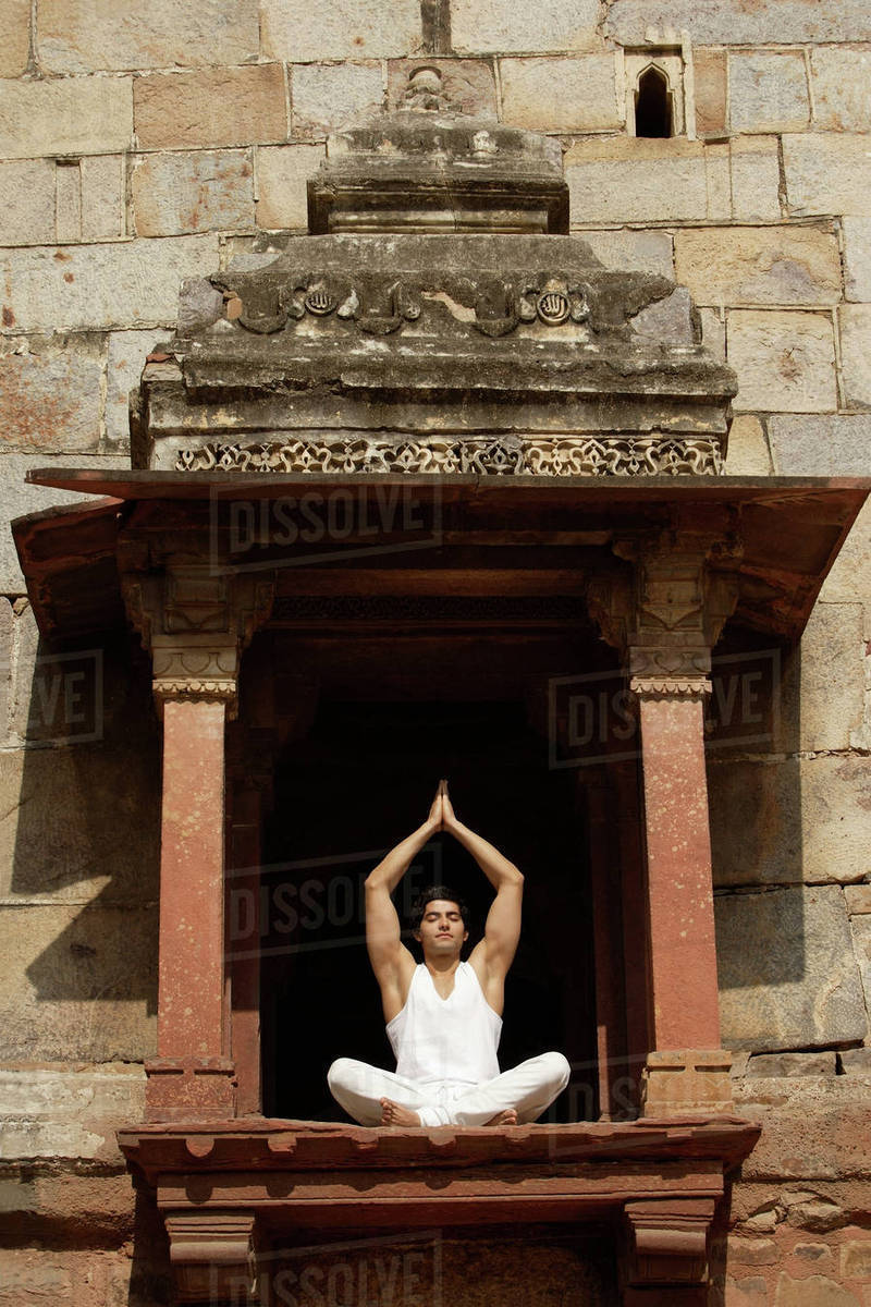 Man in yoga posture sitting in ancient monument - Royalty-free Stock ...