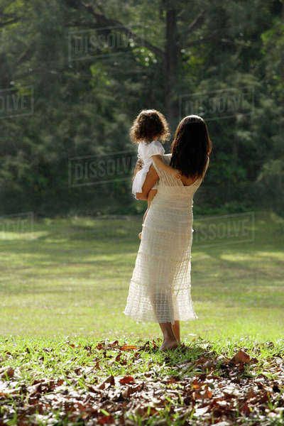 Back view of mother holding child - Stock Photo - Dissolve