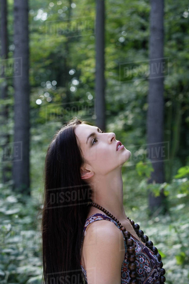 Profile of young woman in forest - Royalty-free Stock Photo | Dissolve