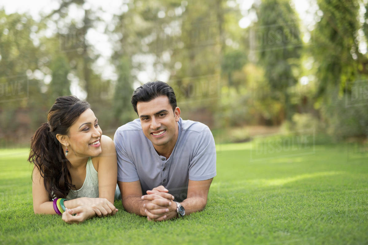 Man and woman lying on grass - Stock Photo - Dissolve