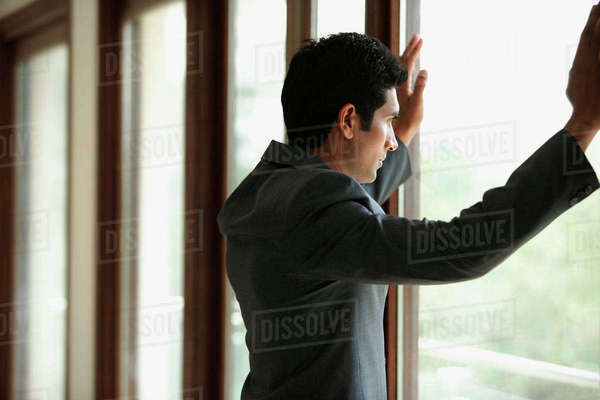Businessman with hands on window - Stock Photo - Dissolve