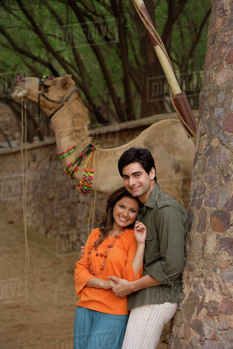 Young couple embracing, camel in background - Stock Photo - Dissolve