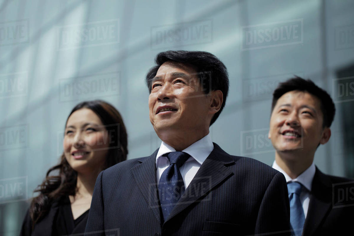 Business people looking up in front of a building - Royalty-free Stock ...