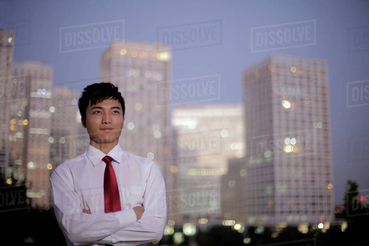 Young man standing in front of buildings in evening, China - Stock ...
