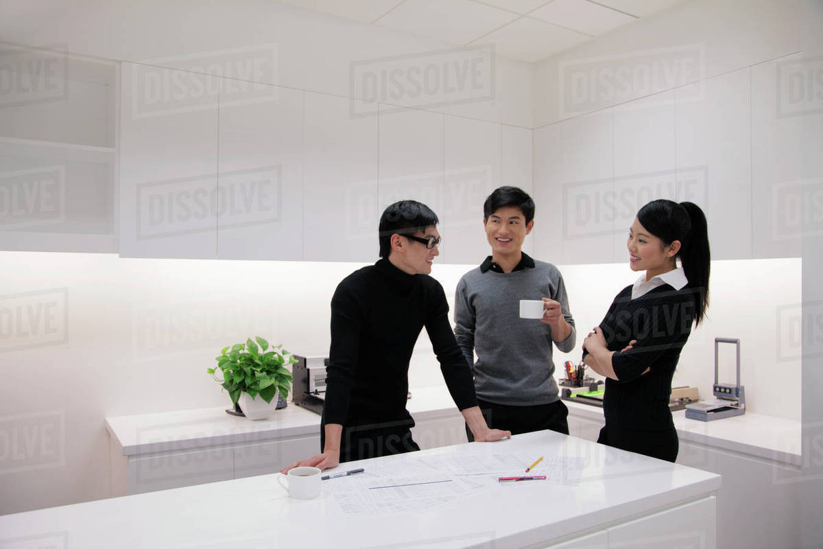 Three people talking in modern office - Royalty-free Stock Photo | Dissolve