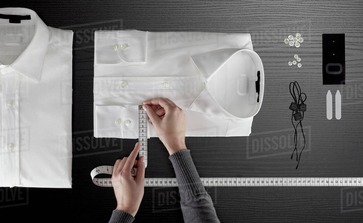 A tailor measuring a button down shirt, focus on hands - Stock Photo ...
