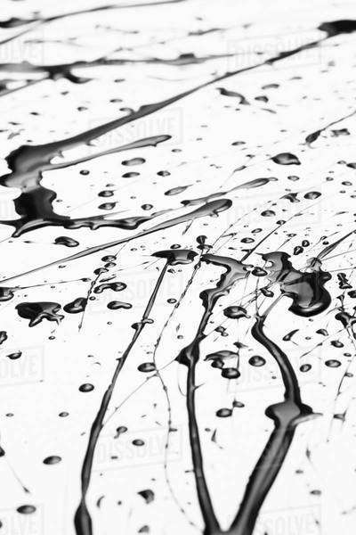 Splattered black paint making a complex abstract pattern on a white ...