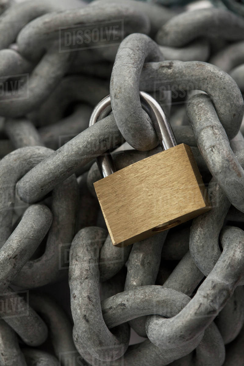 A steel chain with a gold padlock - Royalty-free Stock Photo | Dissolve