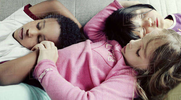 Three kids comfortably napping together on a sofa - Royalty-free Stock ...