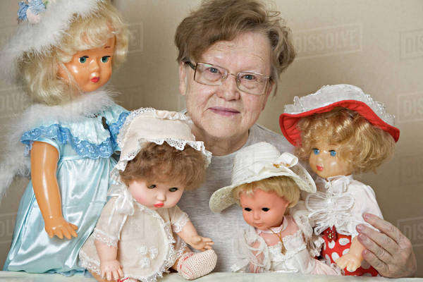 A senior woman with her collection of old-fashioned dolls - Royalty ...