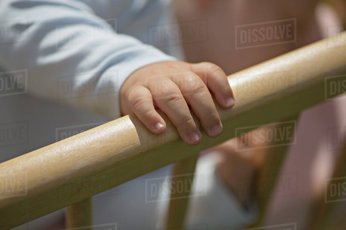 Baby's hand on crib railing - Royalty-free Stock Photo | Dissolve
