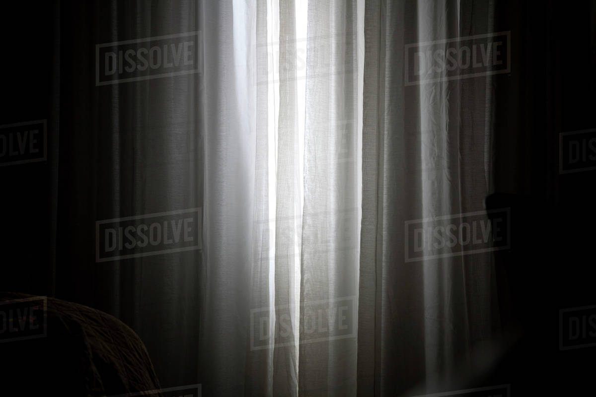 Sunlight coming in through slightly parted curtains in a bedroom ...