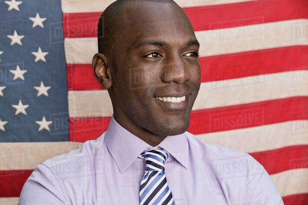 Happy businessman in front of American flag - Stock Photo - Dissolve