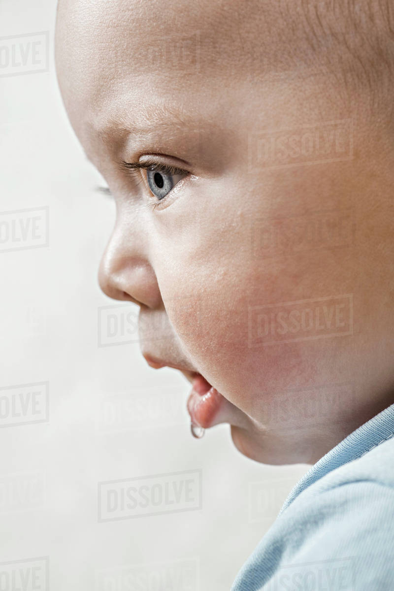 A baby staring off camera and drooling - Stock Photo - Dissolve