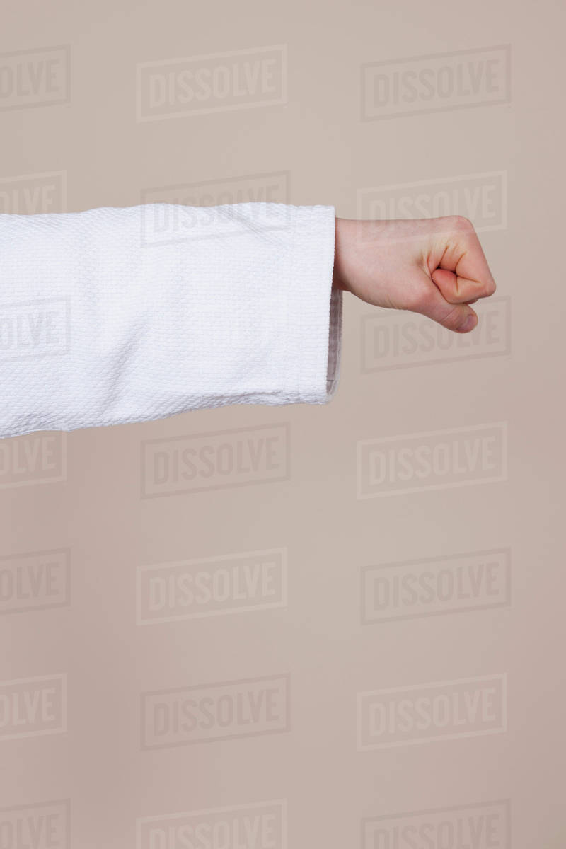 A girl in a martial arts fighting stance, close-up of arm and fist ...