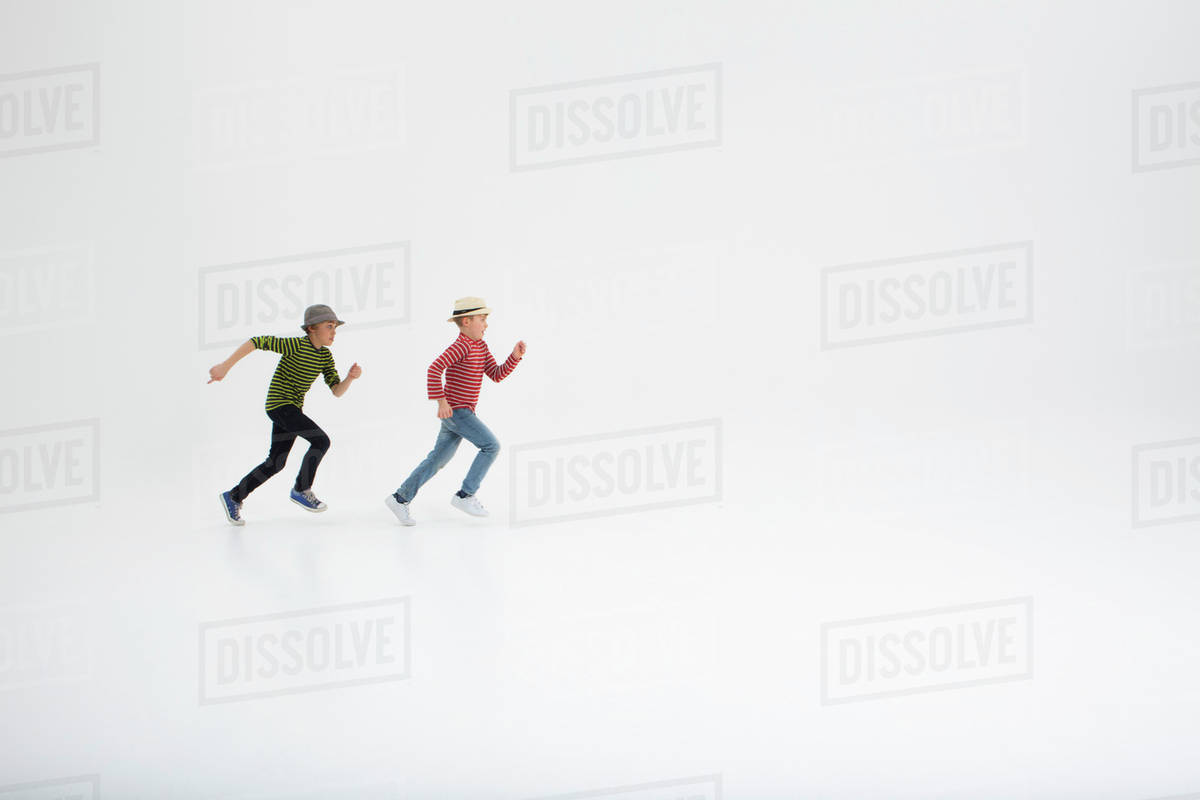 Two boys running against white background - Stock Photo - Dissolve