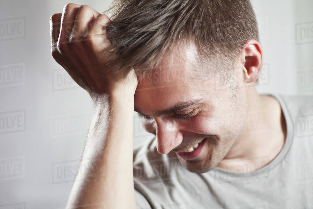 Young man looking down and smiling, close-up - Royalty-free Stock Photo ...