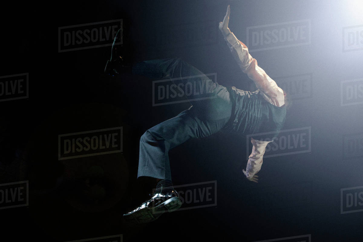 Full length of man dancing against black background - Stock Photo ...
