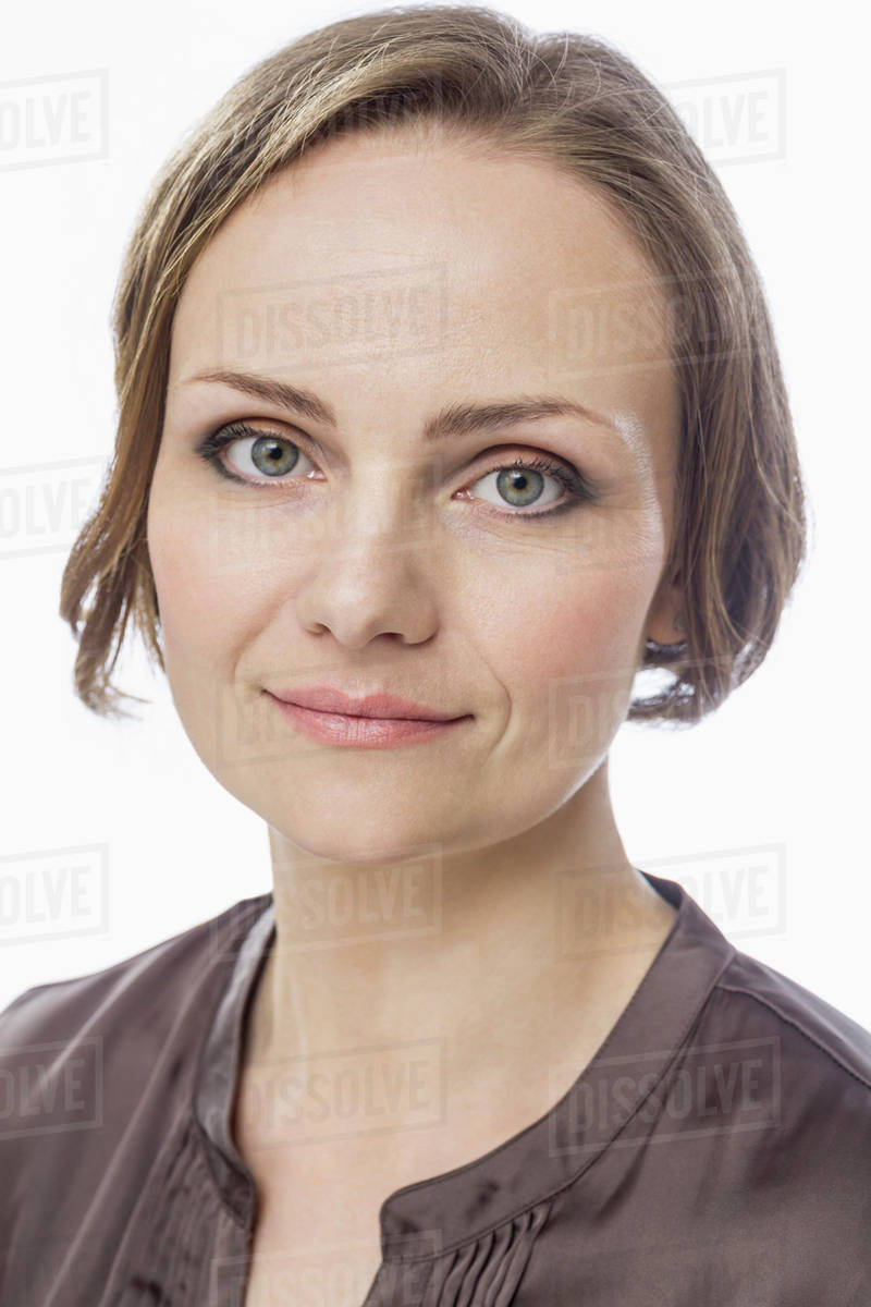 Close-up portrait of confident woman smiling against white background ...