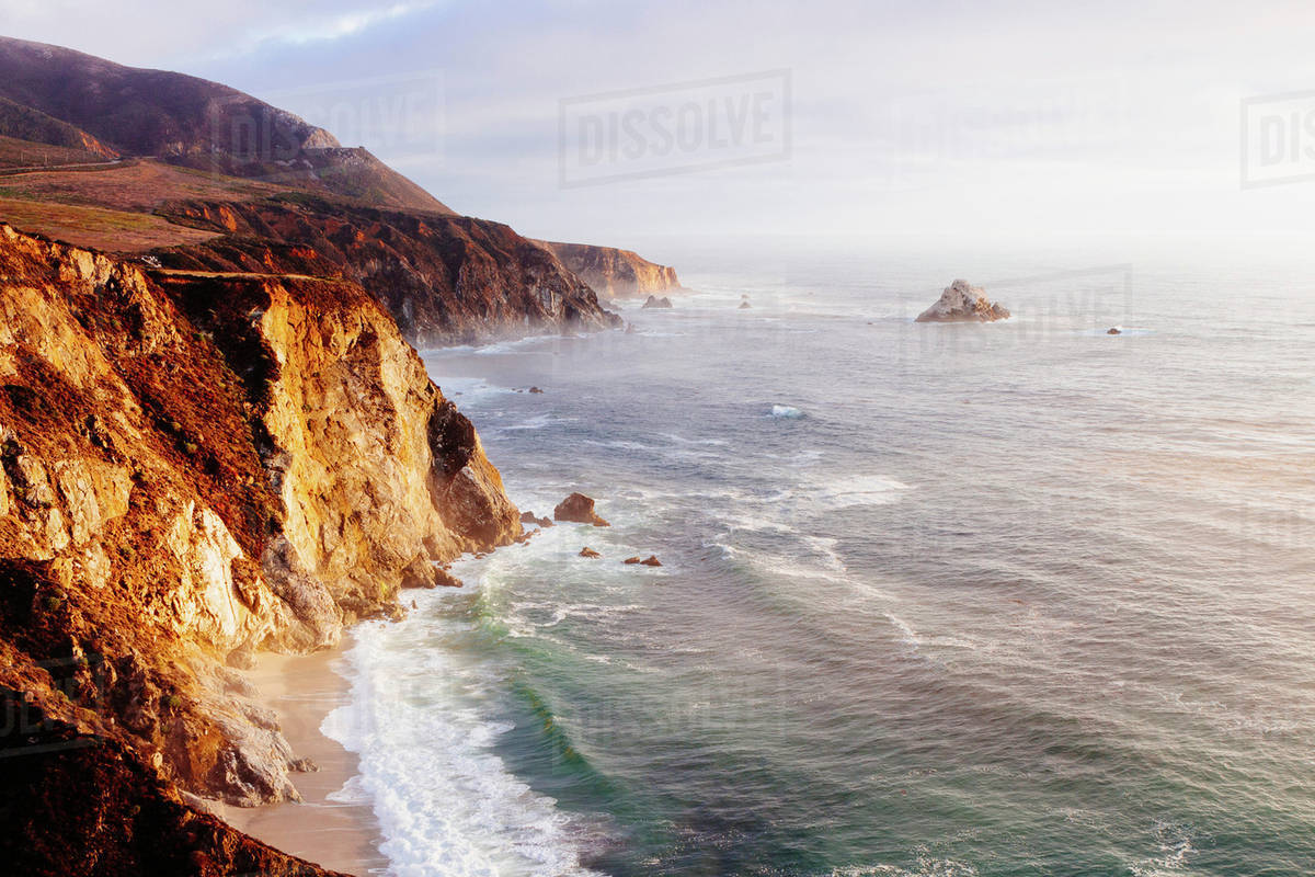 High angle view of rocky cliff by sea - Stock Photo - Dissolve