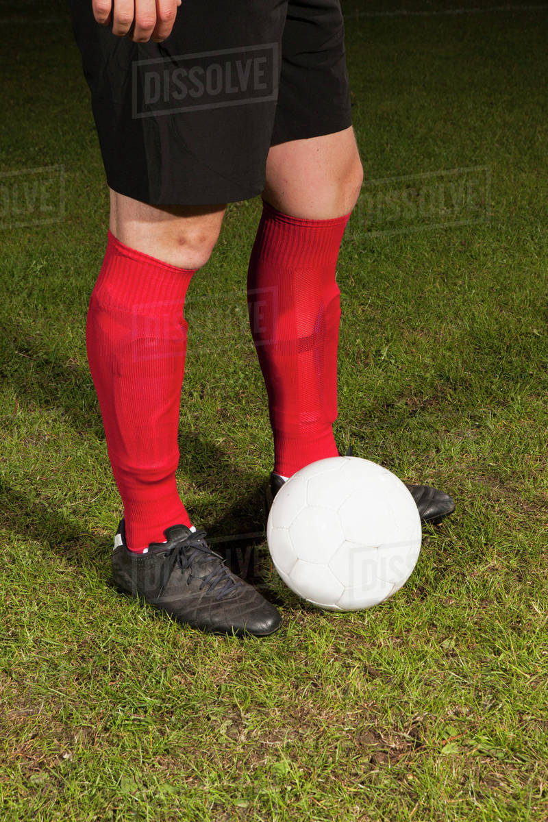 Low section of young soccer player with ball on field - Royalty-free ...