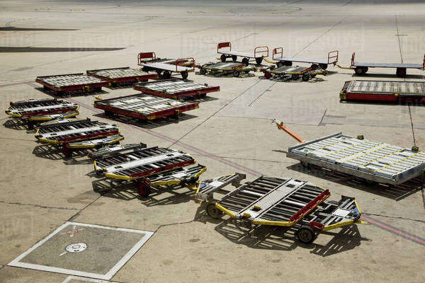 Baggage trailers on an airport tarmac - Royalty-free Stock Photo | Dissolve